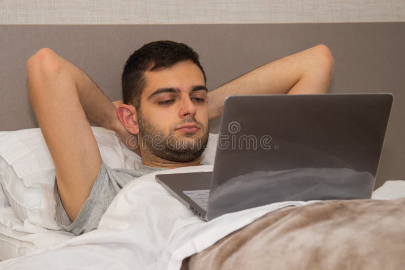 Man in bed with computer stock photo. Image of sleepy - 243018496