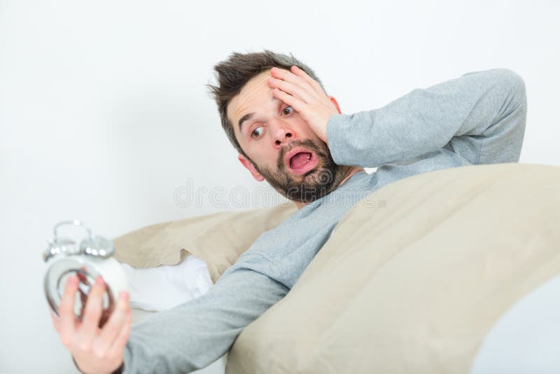 Man in Bed Looking in Horror at Time on Alarmclock Stock Photo - Image ...