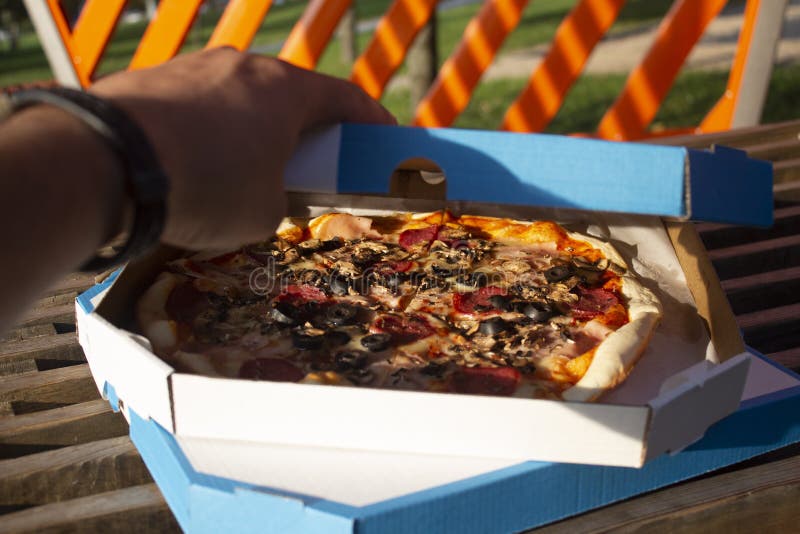 The Man on the Bench is Eating Pizza. Fast Food in the Fresh Air Stock ...