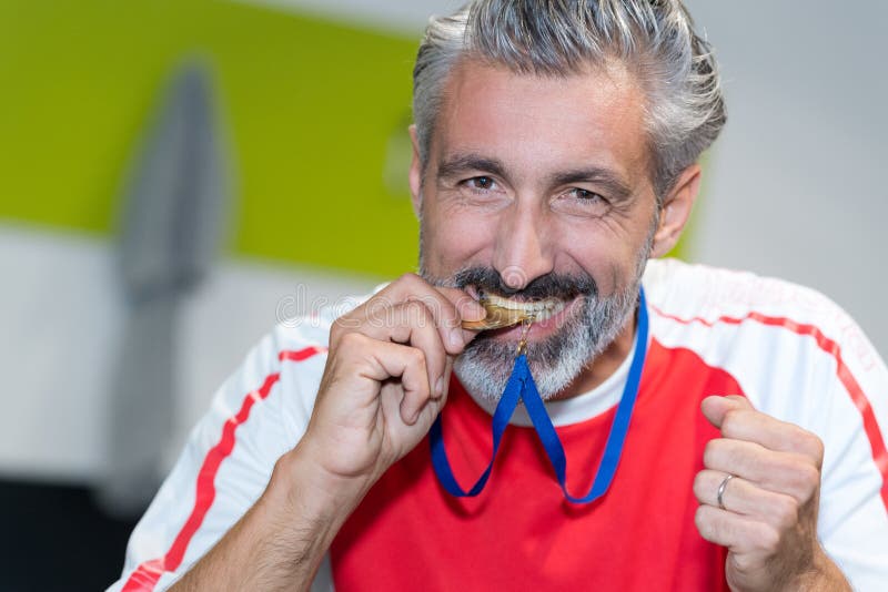 Man biting gold medal stock image. Image of silver, color - 101670175