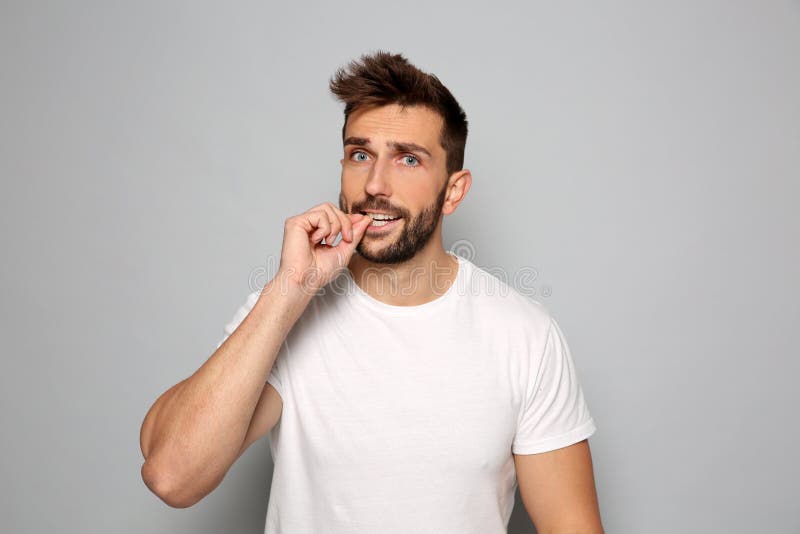 Man Biting His Nails on Grey Background Stock Image - Image of chewing ...