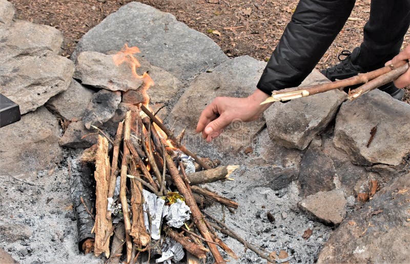 Man Lighting a Fire Outdoors Stock Image - Image of black, folded ...