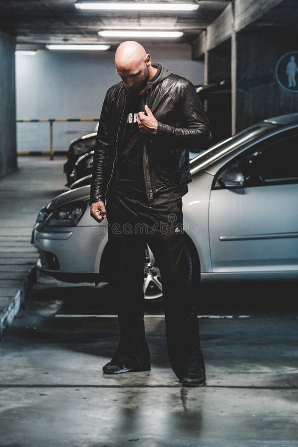 Man in Black Leather Jacket Standing in Front of Gray Car Stock Photo ...
