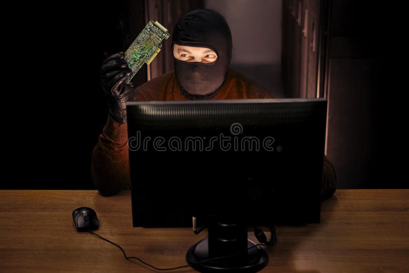 Man in Black Mask with a Printed Circuit Board from a Hacker Device in ...