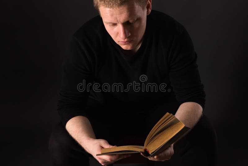 The Man Reading Alone the Book in the Dark at Weak Lighting Stock Photo ...