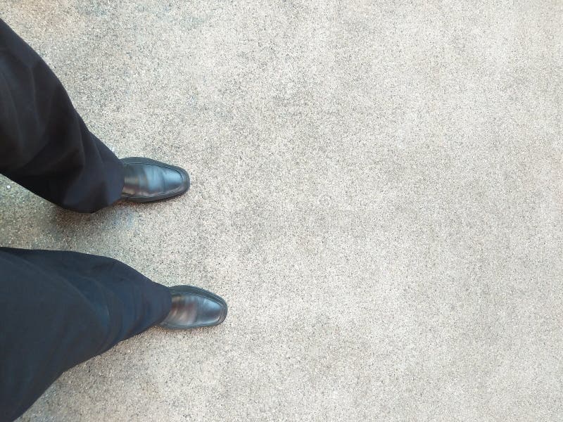 A Man With Black Shoes Standing On Concrete Texture Background Stock