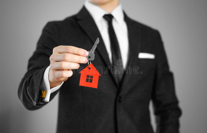 A Man in a Black Suit Holds the Keys To the House. Key Ring Red Stock ...