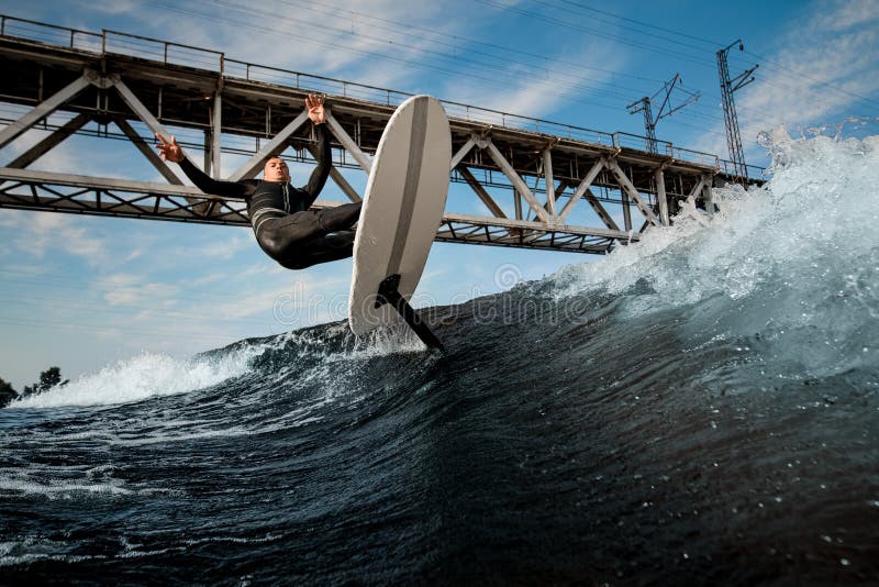 Man Riding the Wave on Foilboard on Background of Bridge and Blue Sky ...