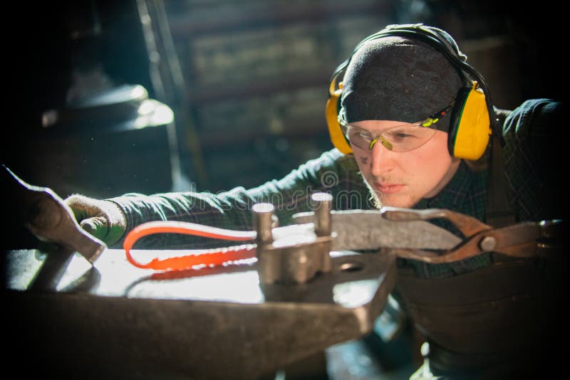 A Man Blacksmith in Protective Glasses Making a Unique Handle - Bending ...