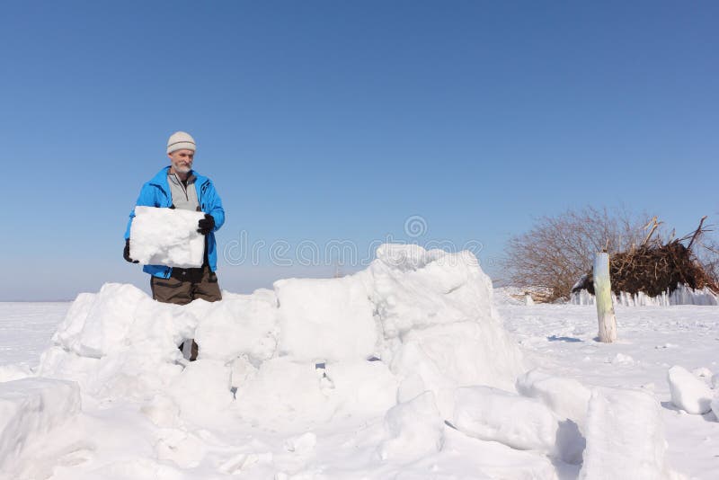 Man in a Blue Jacket Building an Igloo on a Glade Stock Image - Image ...