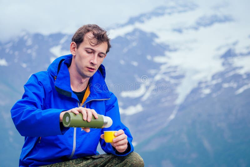 Man in Blue Jacket with Rain in Mountains Tea Drinking Thermos Stock ...