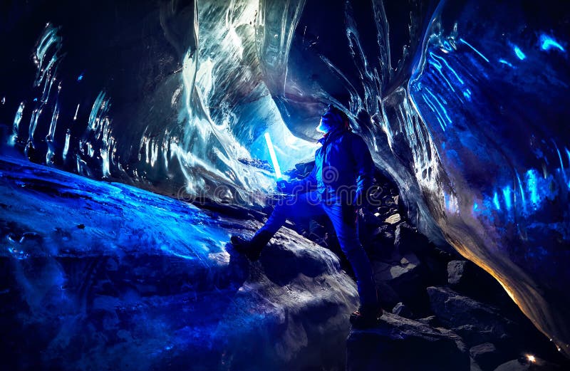 Man with Blue Light Exploring an Amazing Glacial Ice Cave Stock Photo ...