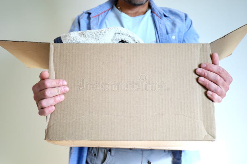 A Man Holds a Cardboard Box with Clothes Inside. Stock Image - Image of ...