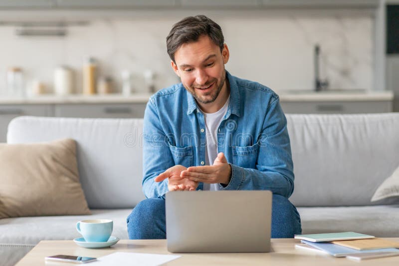 Man in Blue Shirt Talking on Laptop from Couch Stock Image - Image of ...