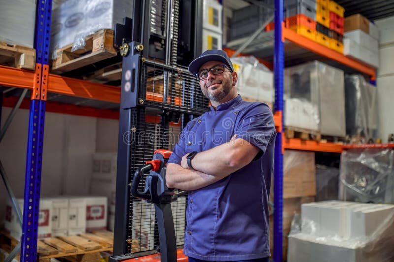 Man in Blue Uniform Standing in Warehouse Stock Photo - Image of ...