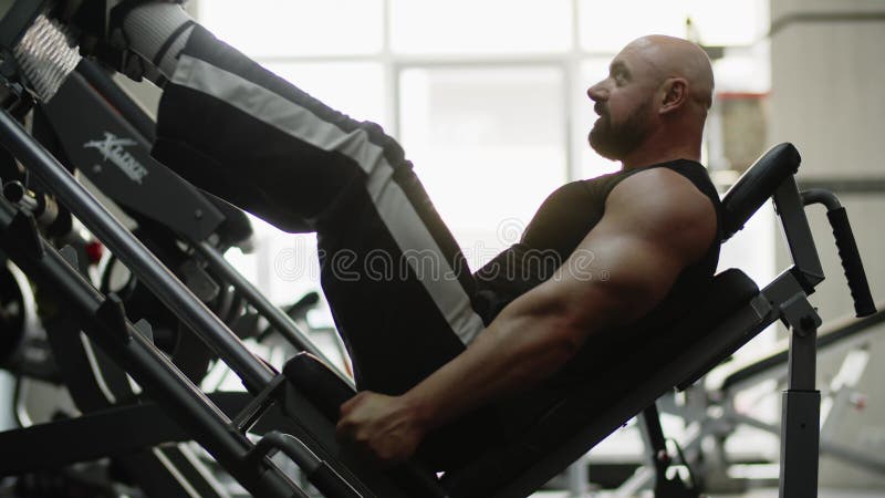 Man Bodybuilder Sideways in the Gym Training on the Machine ...