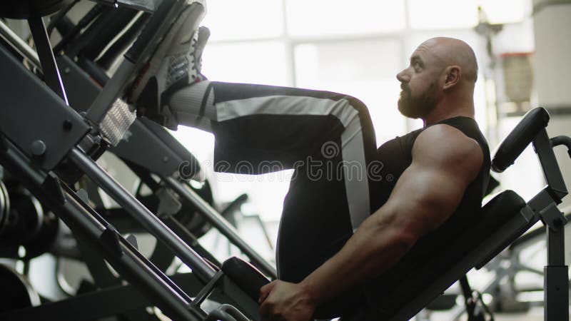 Man Bodybuilder Sideways in the Gym Training on the Machine ...