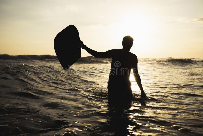 Man with Boogie Board on the Beach at the Sunset Stock Photo - Image of ...
