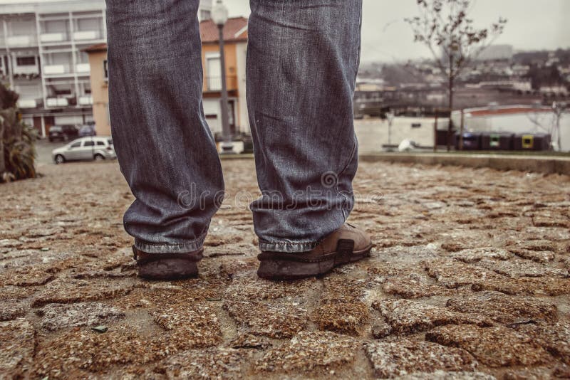 A Man in Boots Stands on a City Road, a Man is Standing on the Sidewalk ...