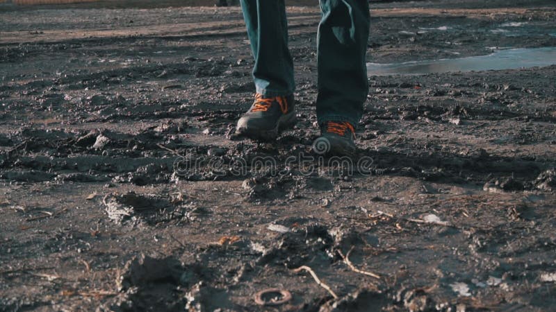 Man in Boots Walks through the Mud, Splashing from a Puddle in Slowmo ...