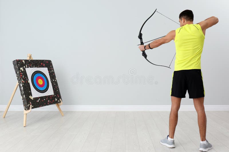 Man with Bow and Arrow Aiming at Archery Target Indoors Stock Image ...