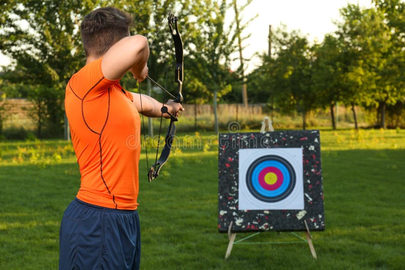 Man with Bow and Arrow Aiming at Archery Target Stock Photo - Image of ...