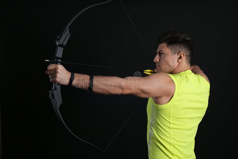 Man with Bow and Arrow Practicing Archery on Black Background Stock ...