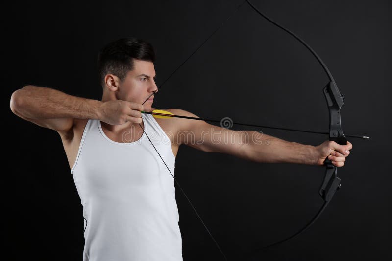Man with Bow and Arrow Practicing Archery on Black Background Stock ...