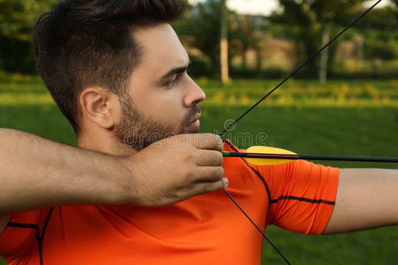 Man with Bow and Arrow Practicing Archery in Park, Closeup Stock Photo ...