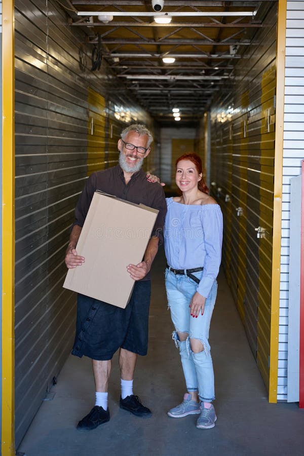 Man with Box and Red-haired Lady are in Storage Warehouse Stock Photo ...