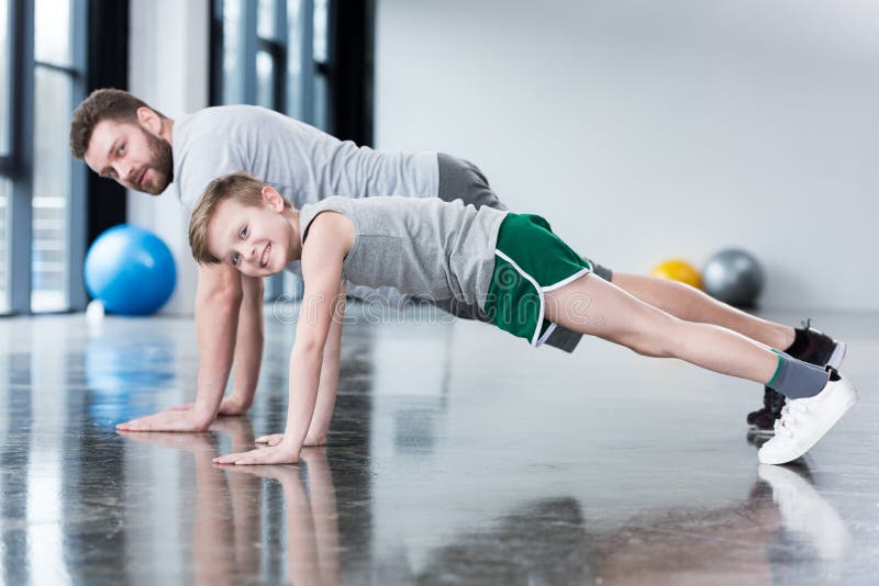 Man and boy doing push ups stock image. Image of exercising - 93603581