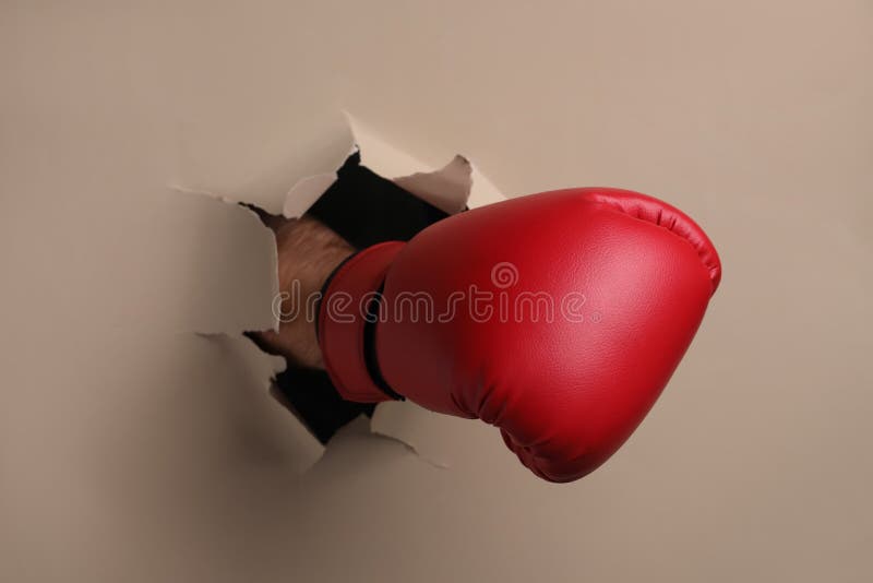 Man Breaking through Beige Paper with Boxing Glove, Closeup Stock Photo ...