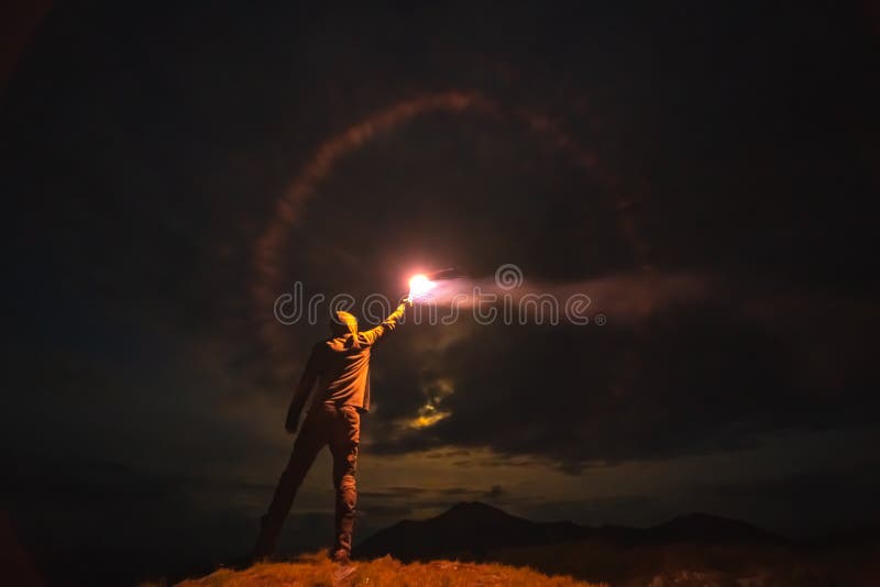 The Man with a Bright Firework Stick Standing on a Mountain. Evening ...
