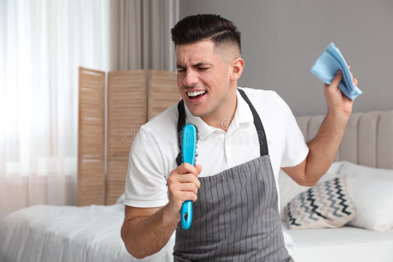 Man with Brush and Rag Singing while Cleaning in Bedroom Stock Image ...