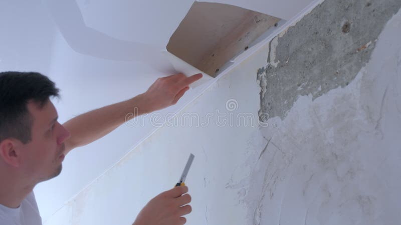 Man Builder Dismantling of Stretch Suspended Ceiling Cutting it Using ...