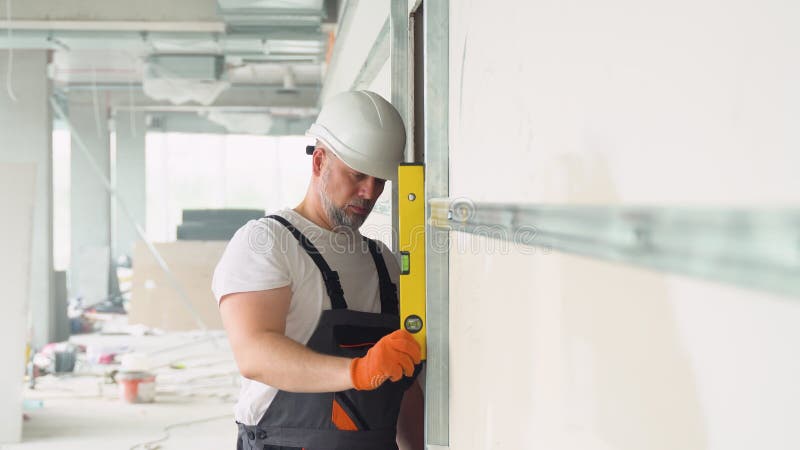 A Man Builder Measures of the Vertical Deviation of Plasterboard Wall ...