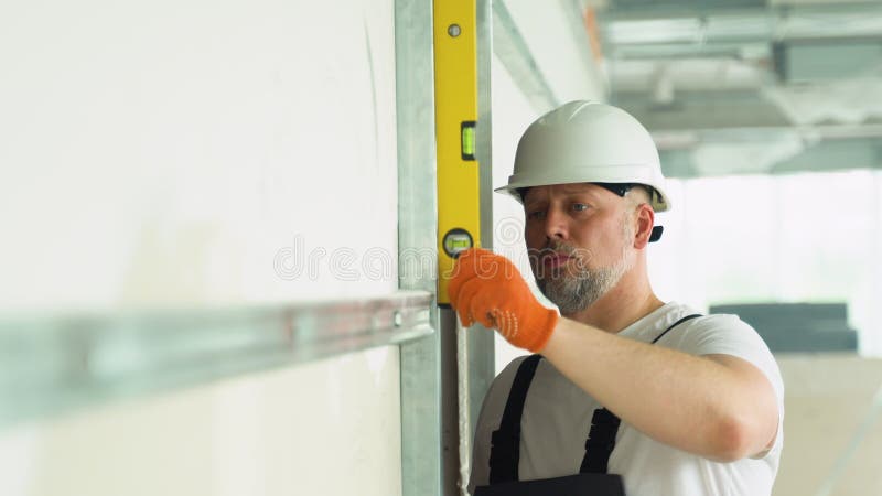 A Man Builder Measures of the Vertical Deviation of Plasterboard Wall ...