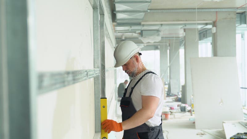 A Man Builder Measures of the Vertical Deviation of Plasterboard Wall ...