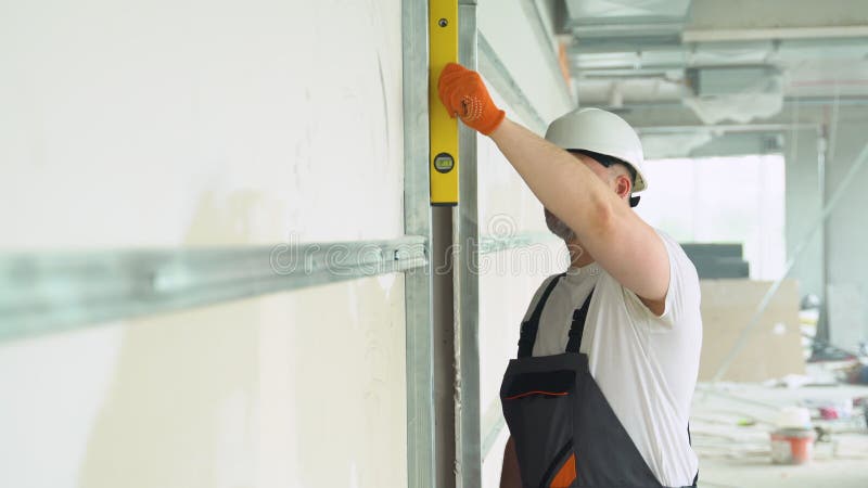 A Man Builder Measures of the Vertical Deviation of Plasterboard Wall ...