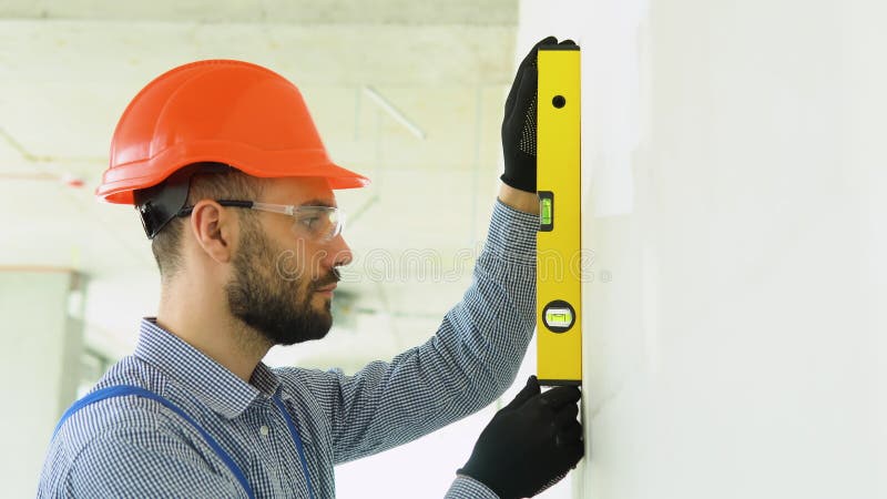 A Man Builder Measures of the Vertical Deviation of Plasterboard Wall ...