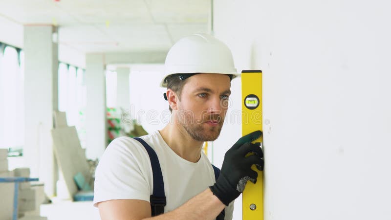 A Man Builder Measures of the Vertical Deviation of Plasterboard Wall ...