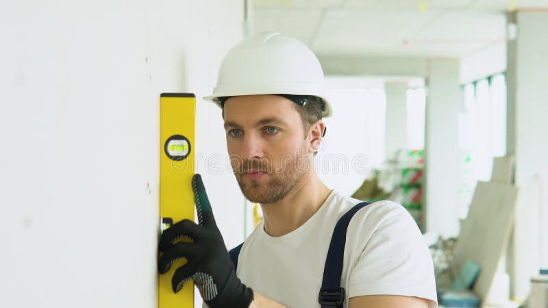 A Man Builder Measures of the Vertical Deviation of Plasterboard Wall ...