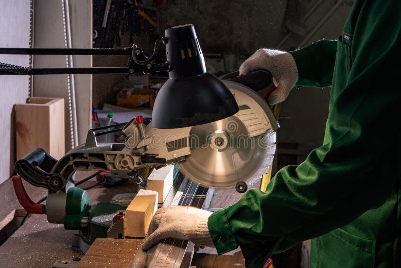 A Man Builder Saws a Board with a Circular Saw in the Workshop Stock ...