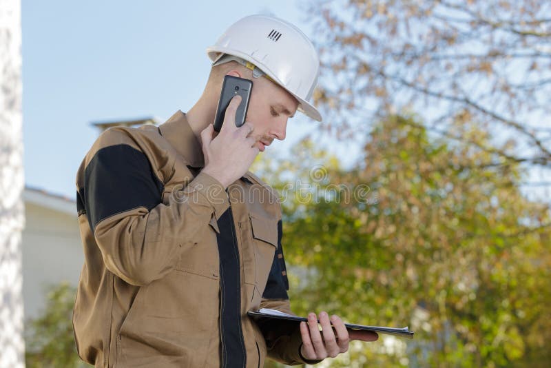 Man builder uses phone stock image. Image of cellphone - 174012183
