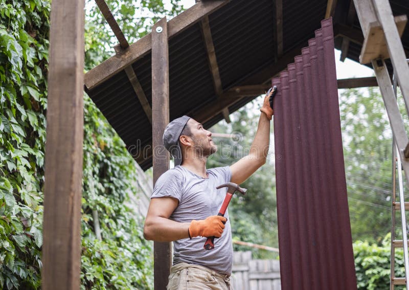 Man Building Roof and Holding Hammer and Roof Material. Stock Image ...