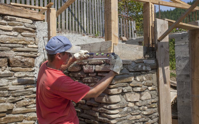 Man building stone wall stock image. Image of builder - 157004167