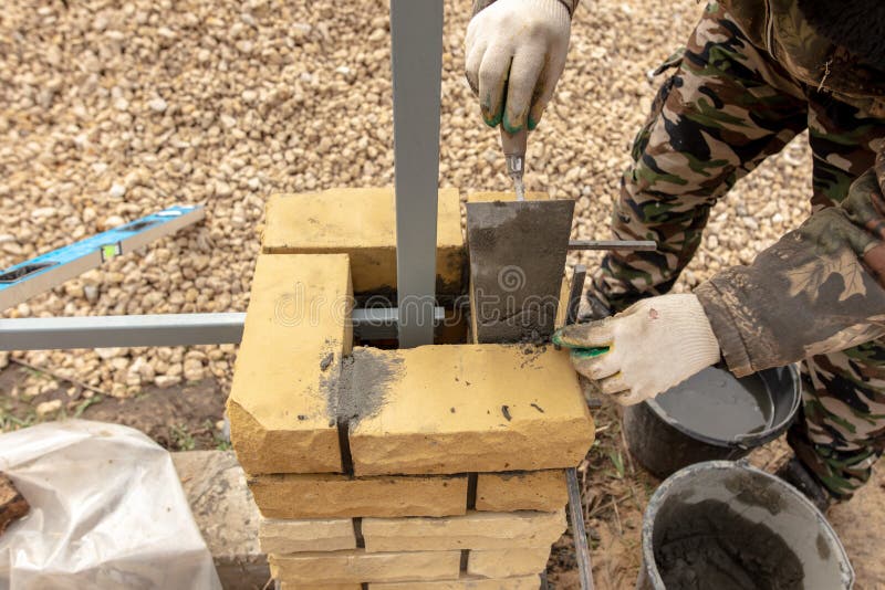 Man Builds a Brick Wall at a Construction Site Stock Photo - Image of ...