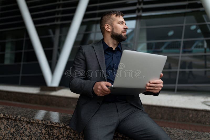 Man in Business Suit Sitting Working on Laptop Outside Stock Image ...