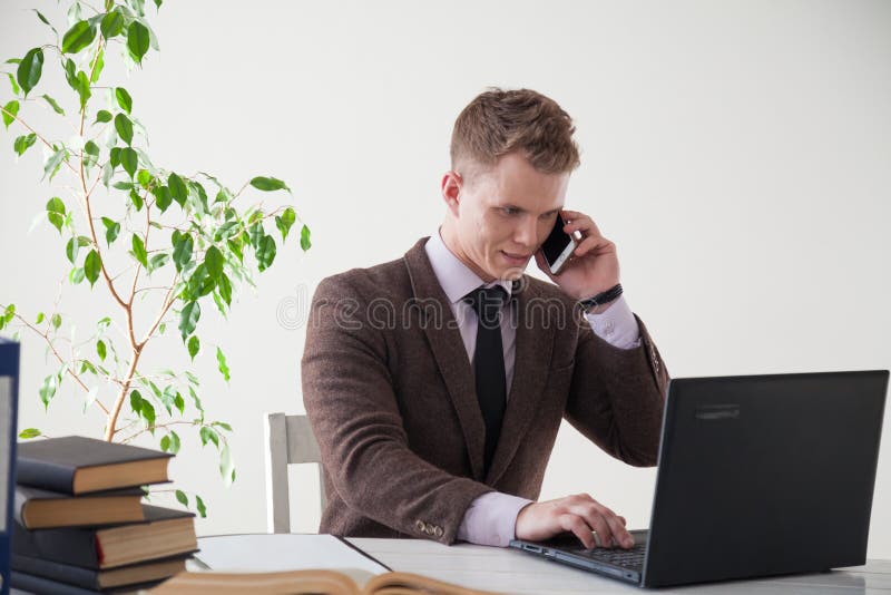 A Man in a Business Suit Works at a Computer in the Office Stock Photo ...