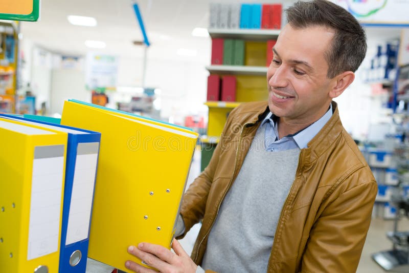 Man buys folders in store stock photo. Image of autumn - 317244464